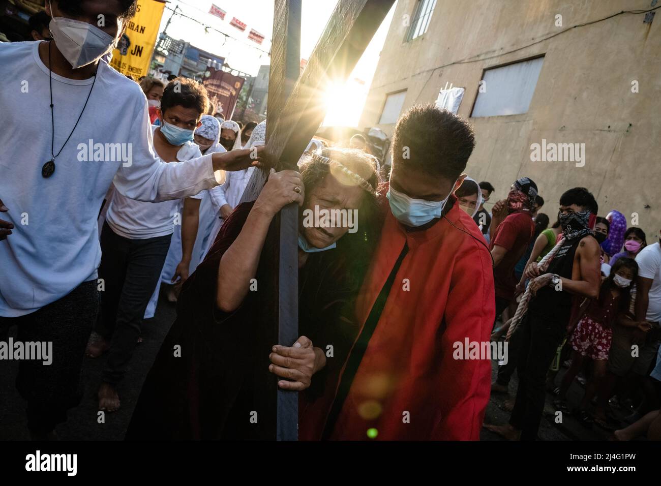 A woman carries a cross during public display of penitence on Good ...