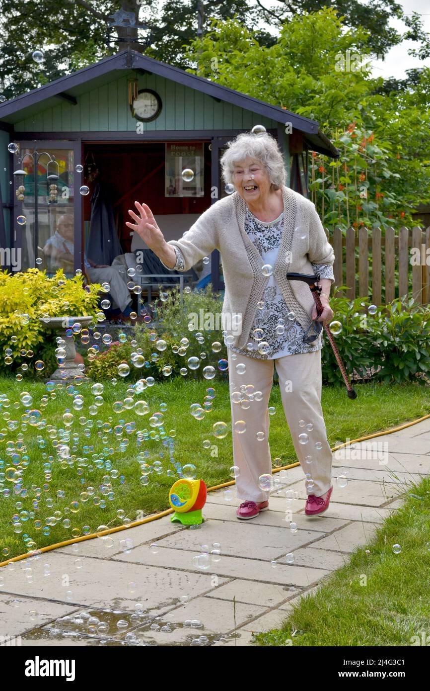 Grandmother Having Fun With Bubbles In Garden Proving Youre Never Too