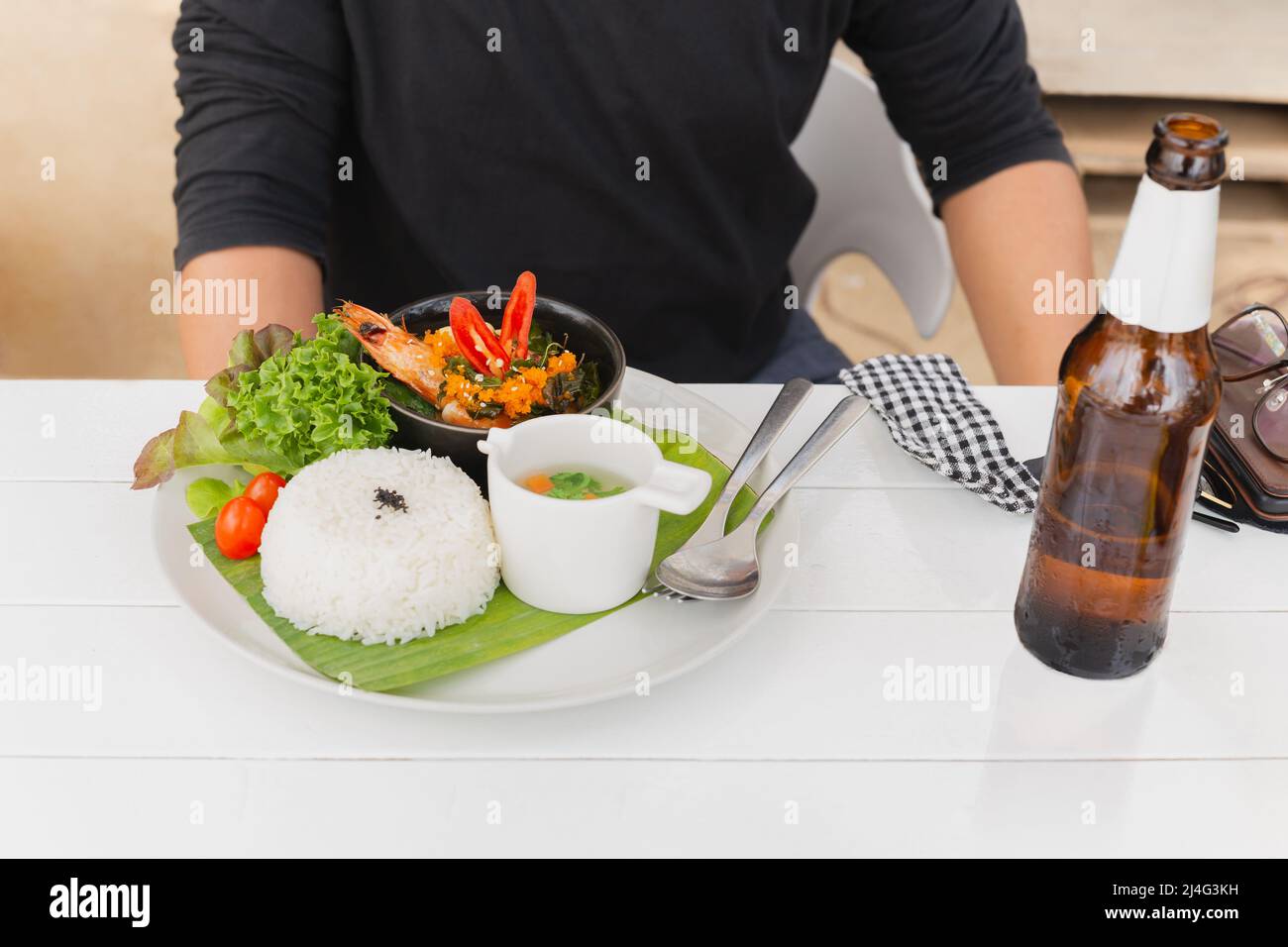 Man eating Thai famous dish pad kra pao stream rice with king prawn on ...