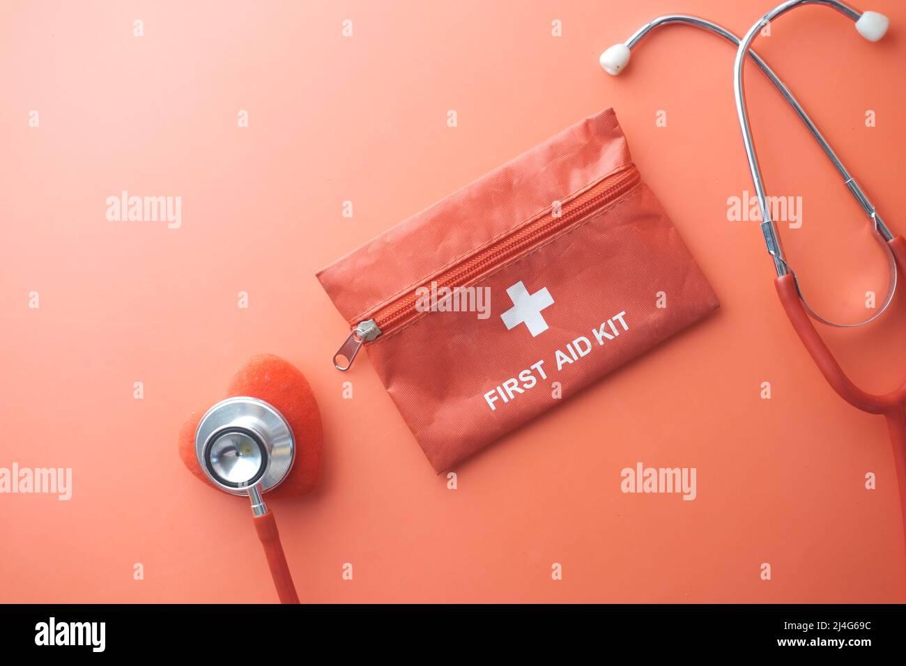 top view of first aid kit, heart shape symbol and stethoscope on red ...