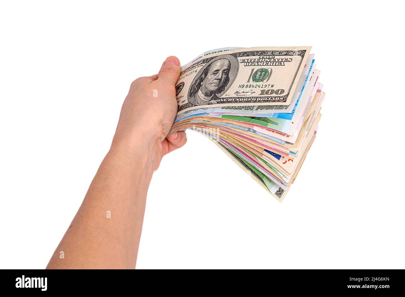 a hand holding a bundle of banknotes of different countries, isolated ...