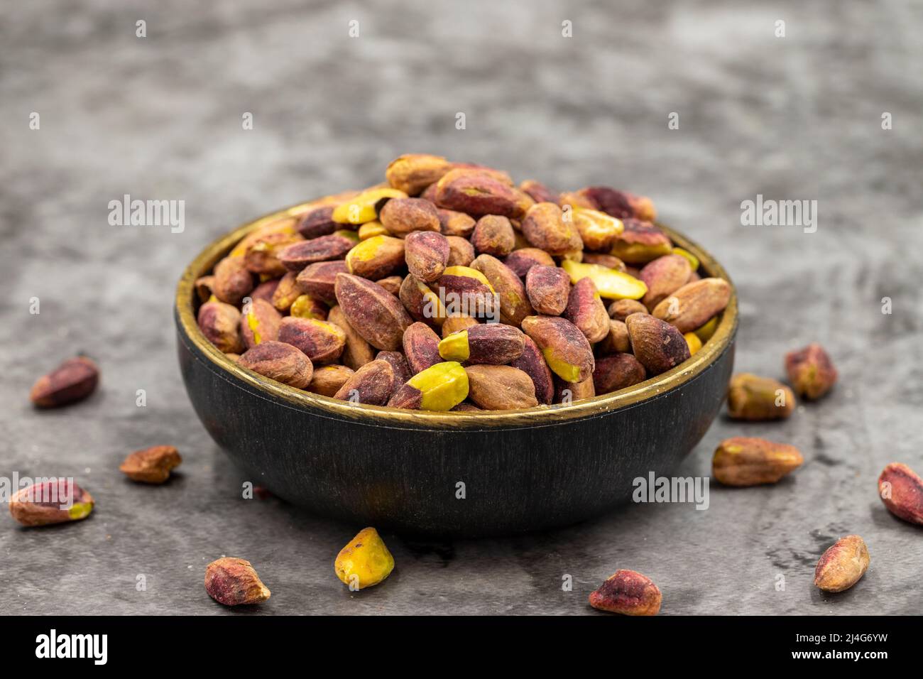 Pistachio kernel on dark background. A bowl of pistachios. close up ...