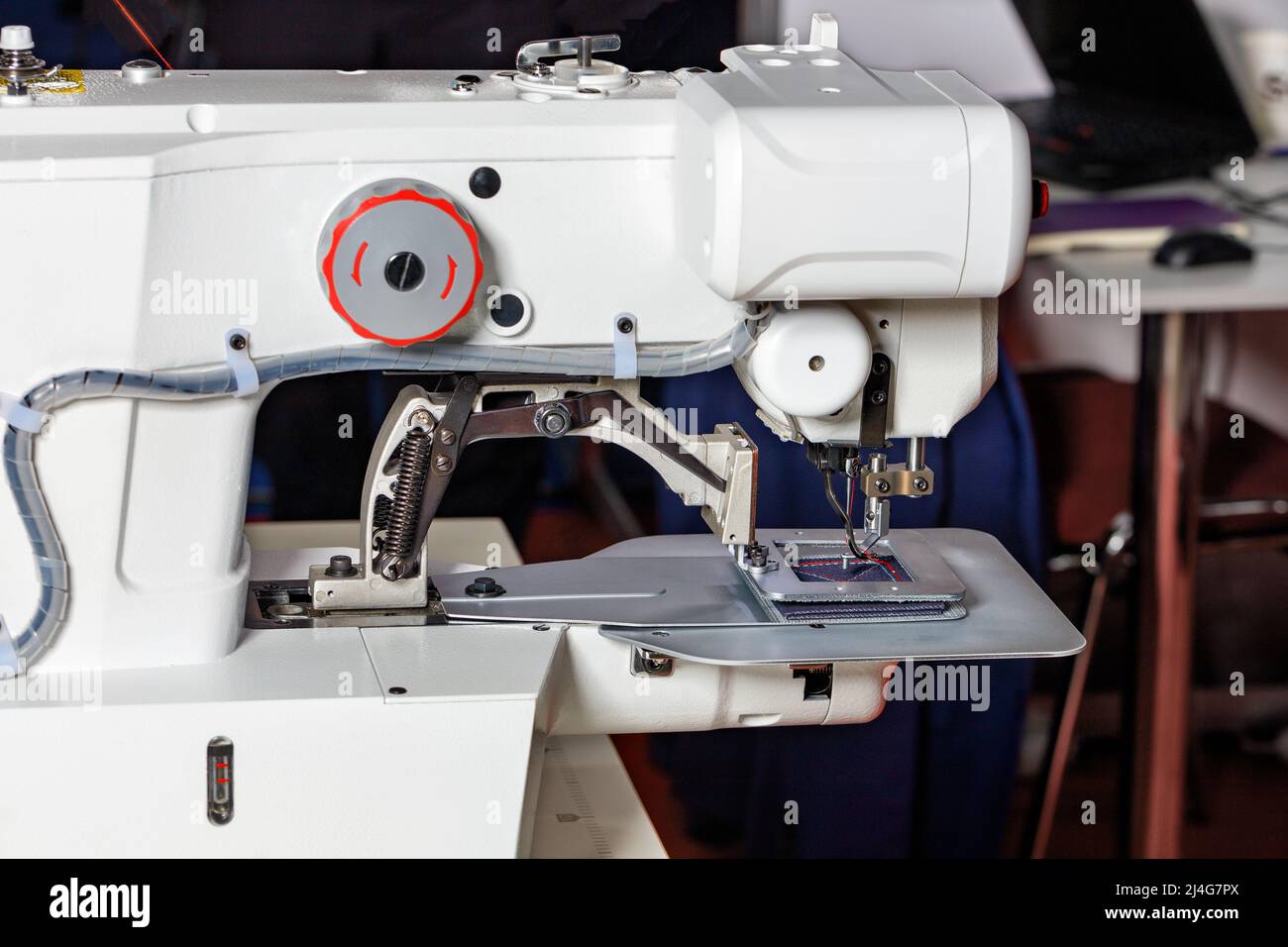 A fragment of a professional sewing machine close-up for sewing thick ...