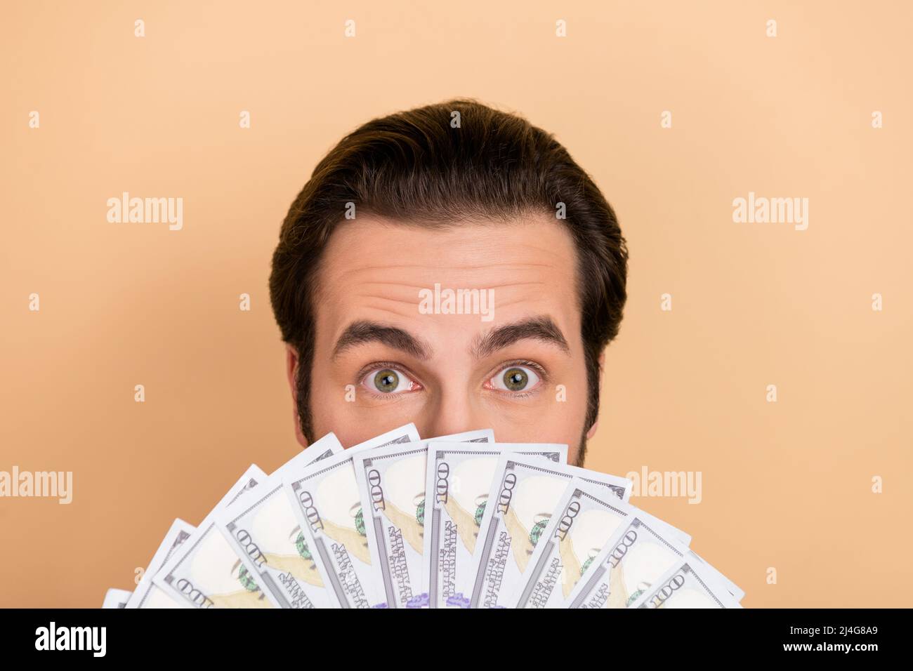 Photo of young person cover face behind banknotes look camera isolated ...