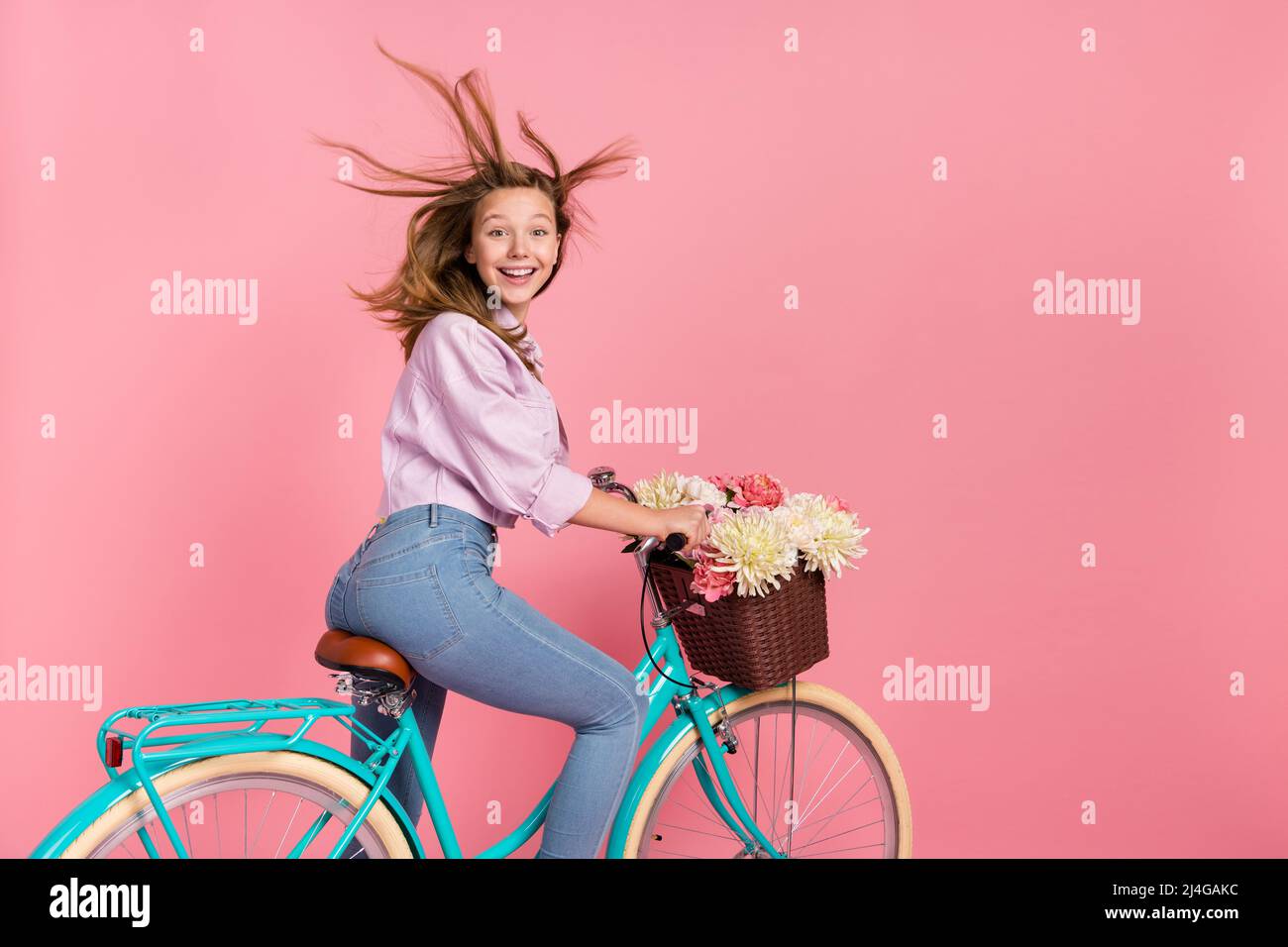 Photo of surprised glad lady drive bike wind blow hair toothy smile ...