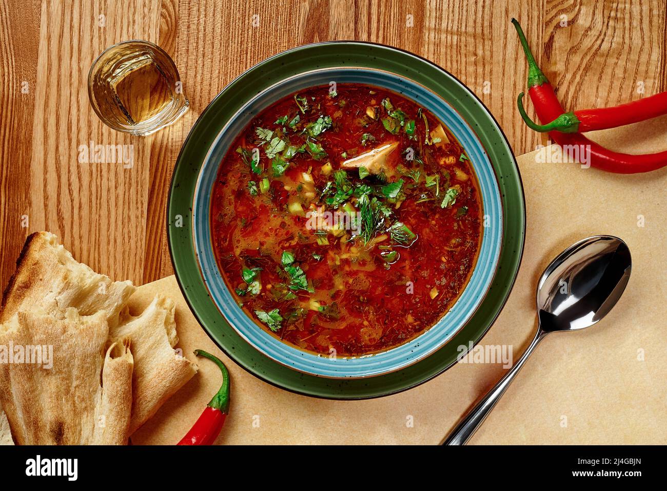 Spicy shurpa with lamb, vegetables and greens served with flatbread and ...