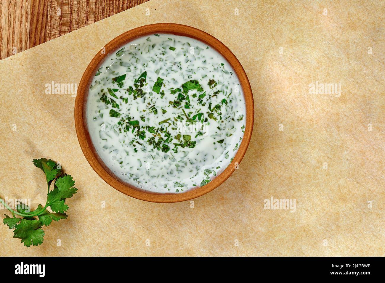 Clay bowl with creamy sauce of matsoni with fresh greens Stock Photo ...