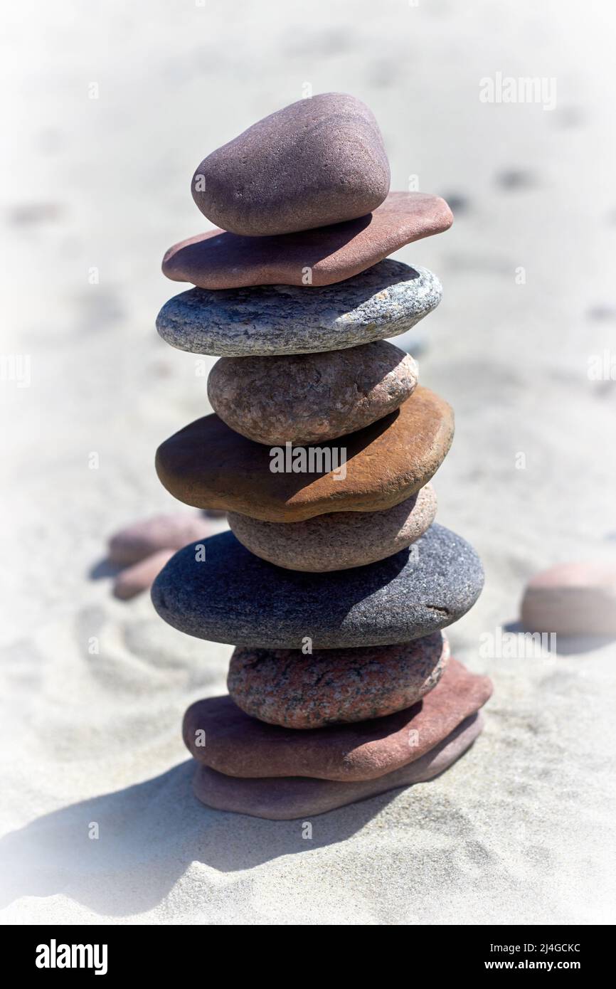 Pyramid of stones on a sandy beach. Zen balance stones in sunshine ...