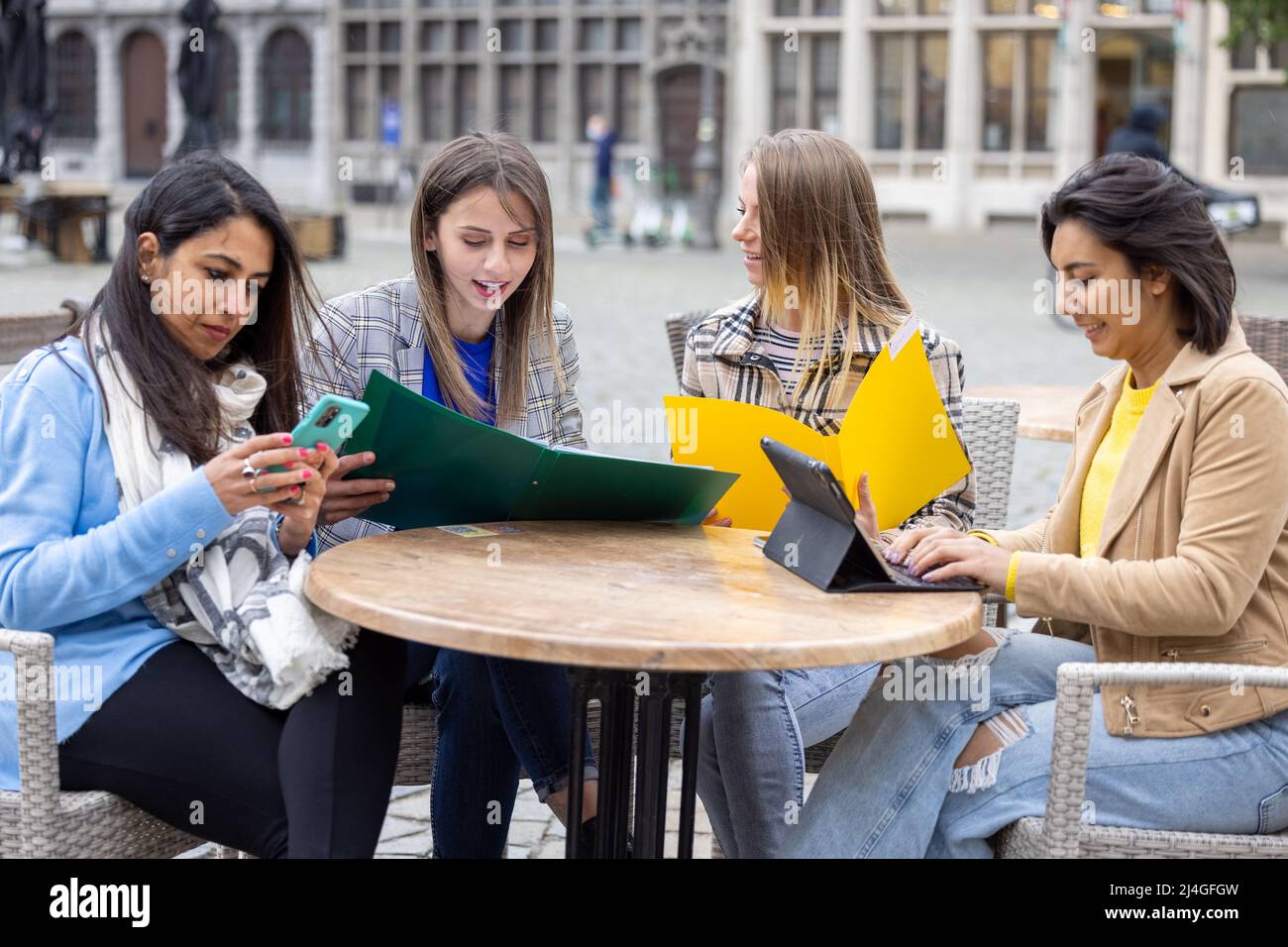 Diverse group of young business woman discussing something on a laptop ...
