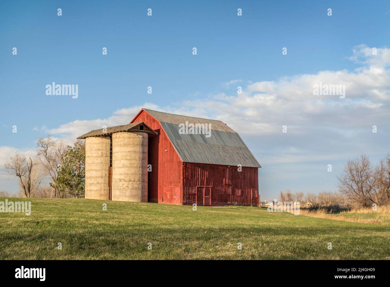 old red barn with twin silo and irrigation ditch at Colorado foothills ...