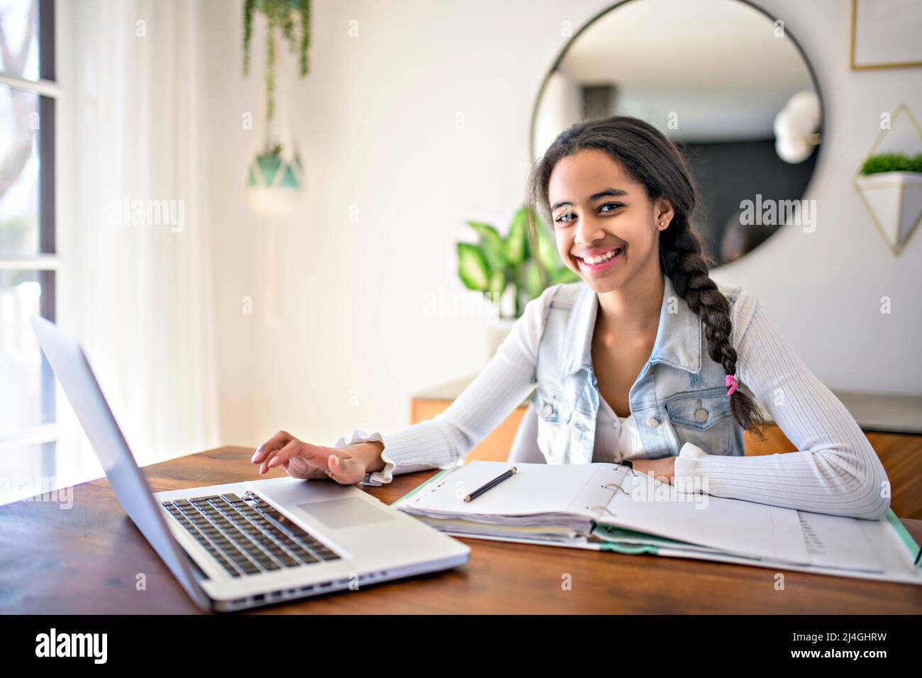 American teen girl learning school tasks at home, writing notes on the ...
