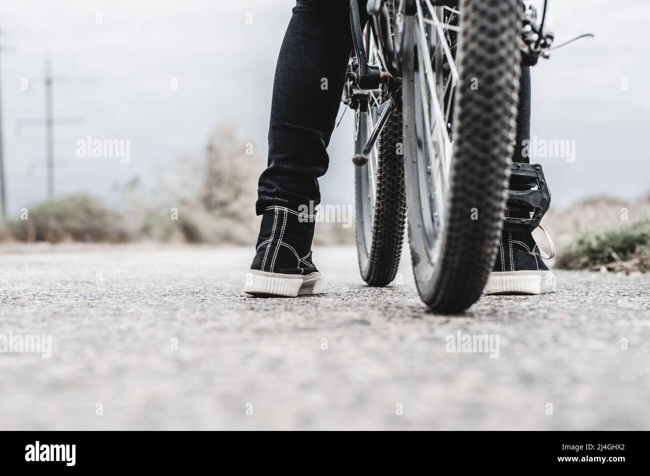 Rear view of the legs and bike of an unrecognizable teenager. Bicycling ...
