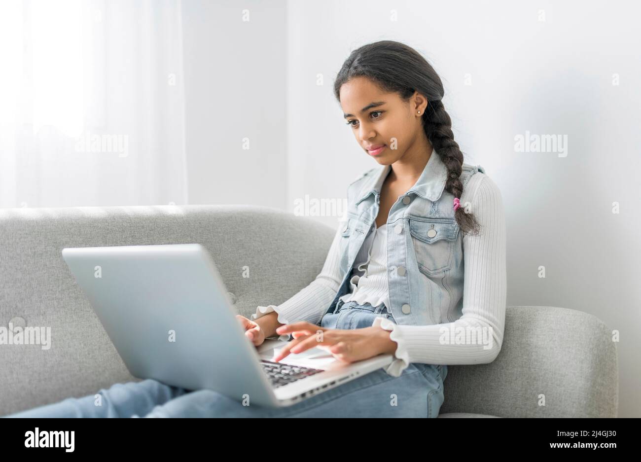 African Teen Girl Using Laptop Computer Browsing Internet Sitting On ...