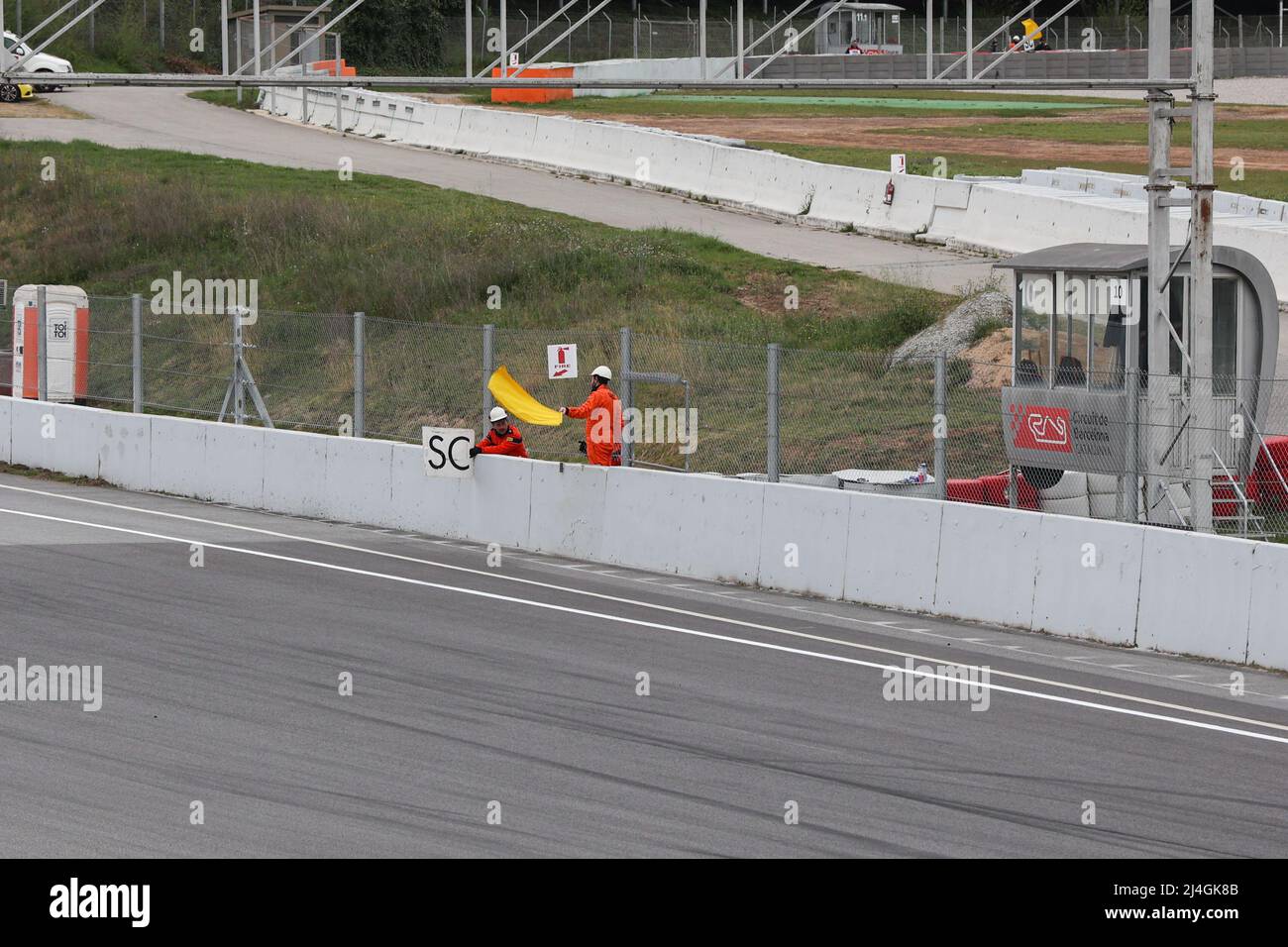 Race marshall waving yellow flag during track race at Circuit of ...