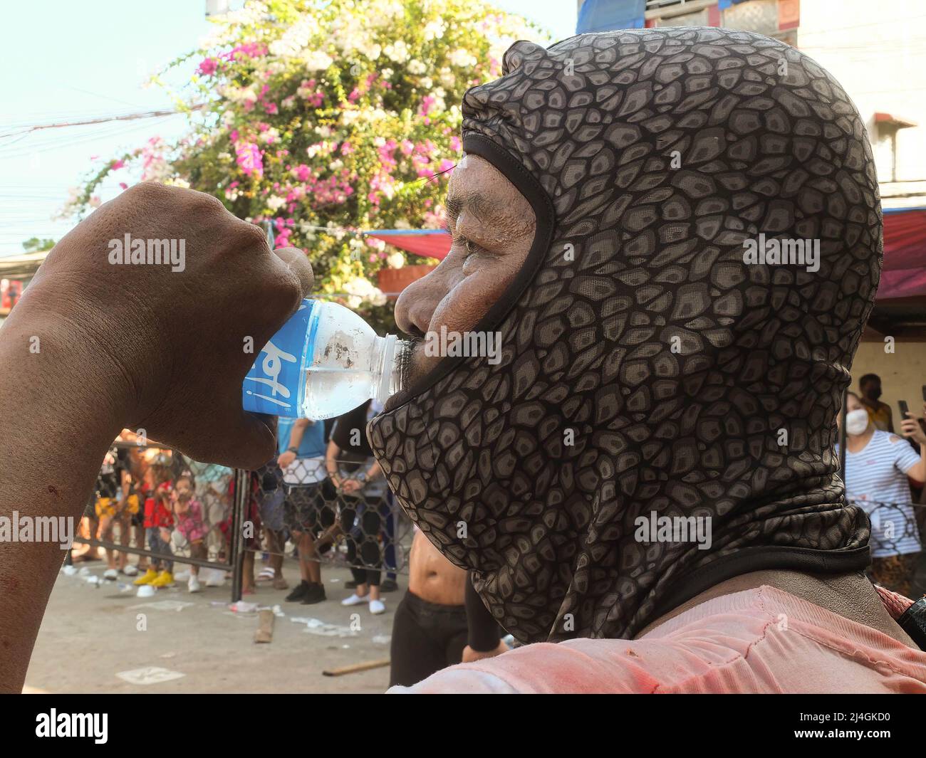 Malabon, Philippines. 15th Apr, 2022. A masked flagellant drinks water ...