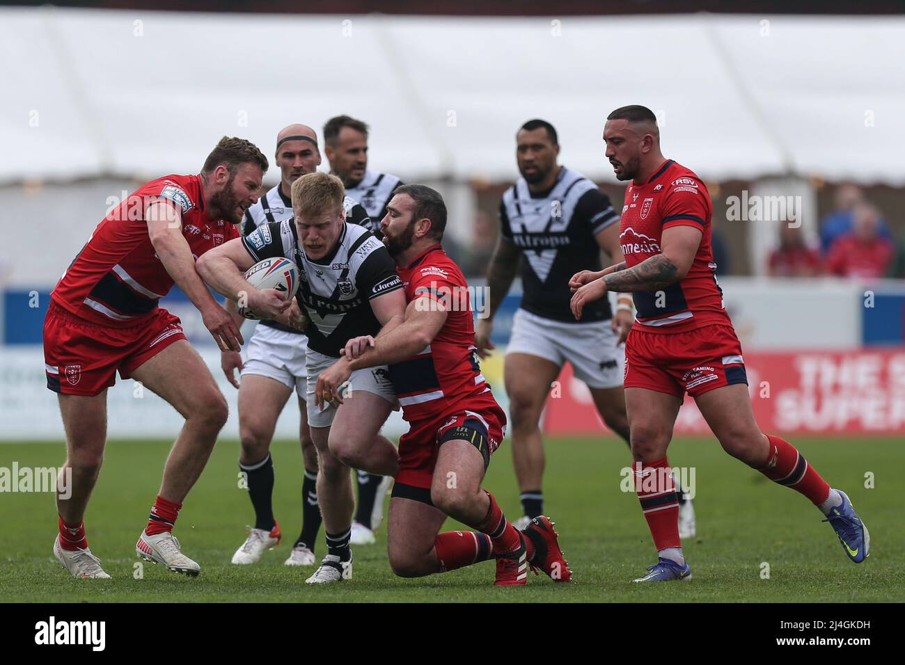 Brad Fash #17 of Hull FC is stopped by Kane Linnett #12 and Will Maher ...
