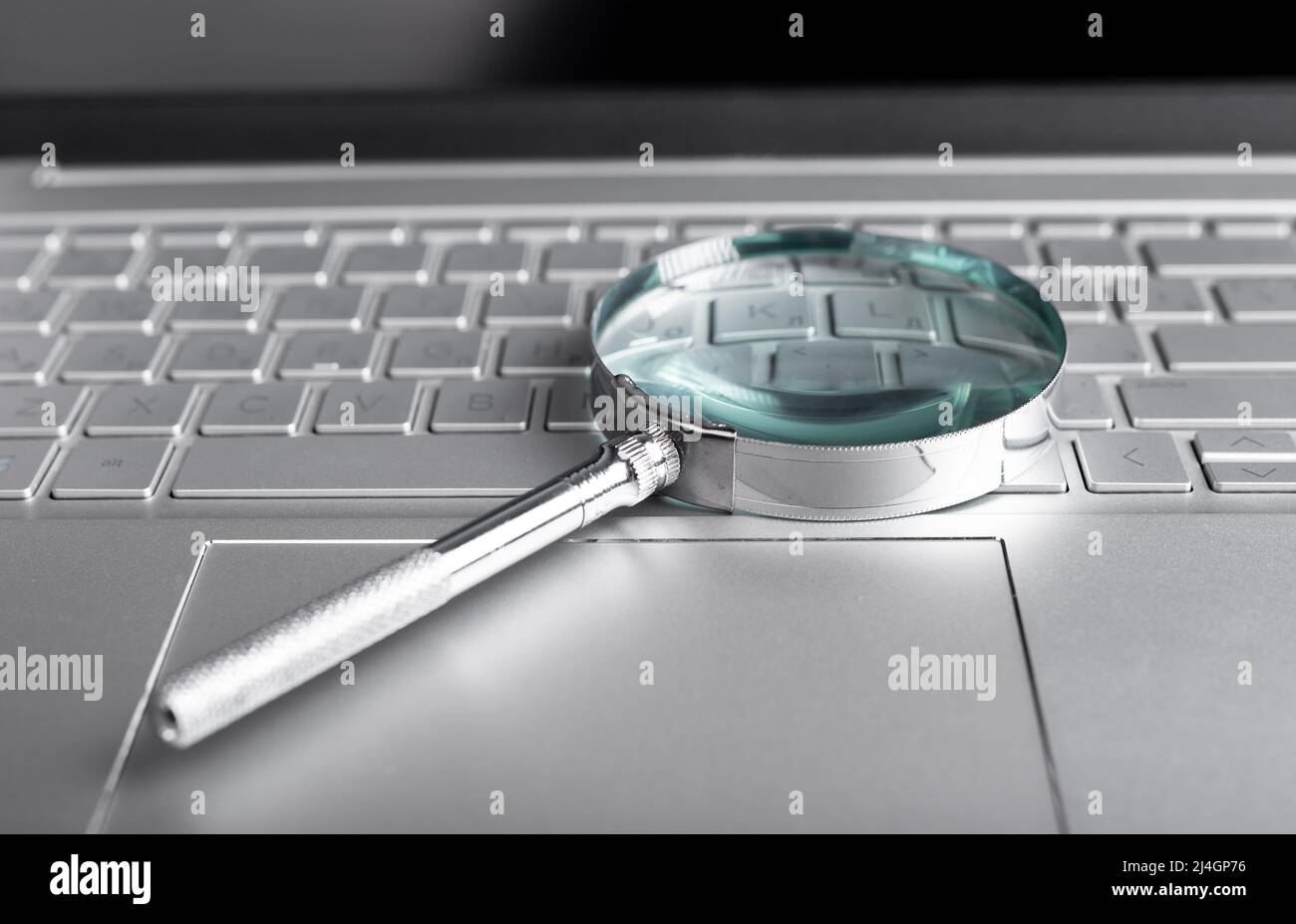 Magnifying glass on laptop keyboard. Information search on Internet ...