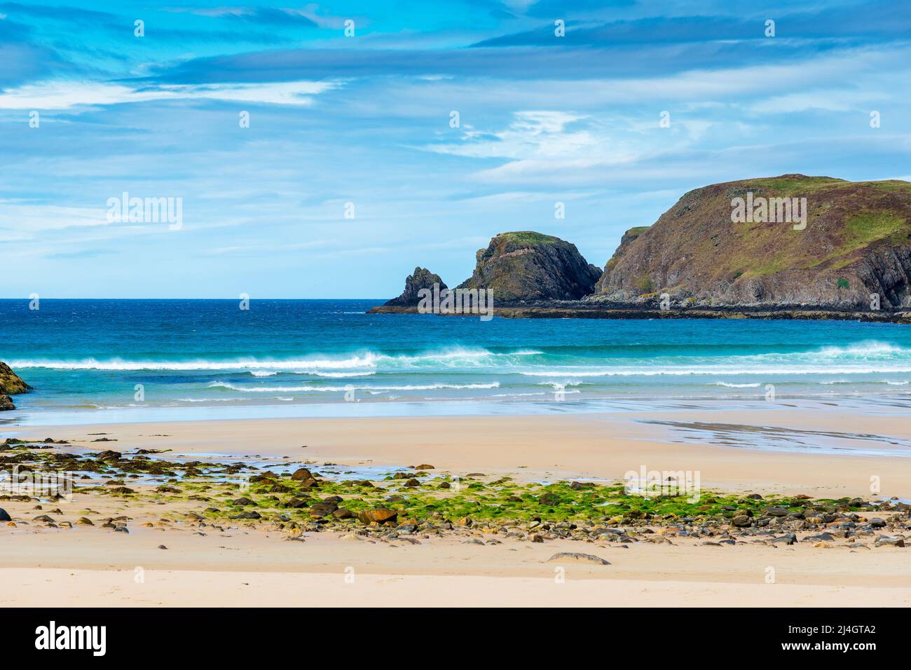 Sparkling white surf contrasts with the blue sea as waves break on the ...