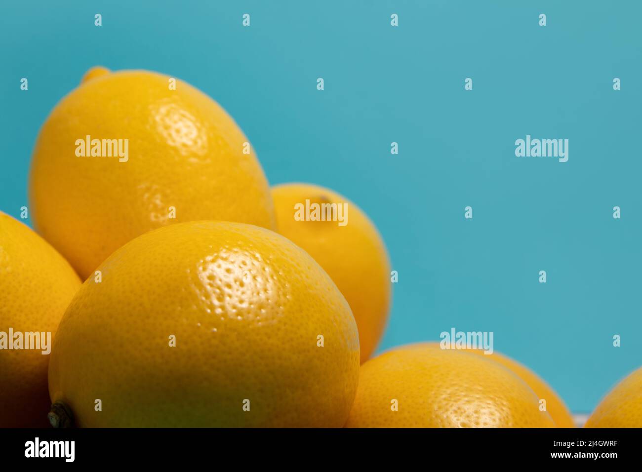Yellow lemons on blue background Stock Photo - Alamy
