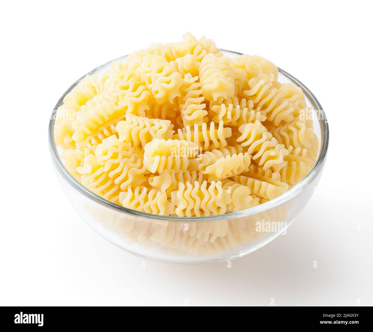 Uncooked radiatori pasta in glass bowl isolated on white background ...