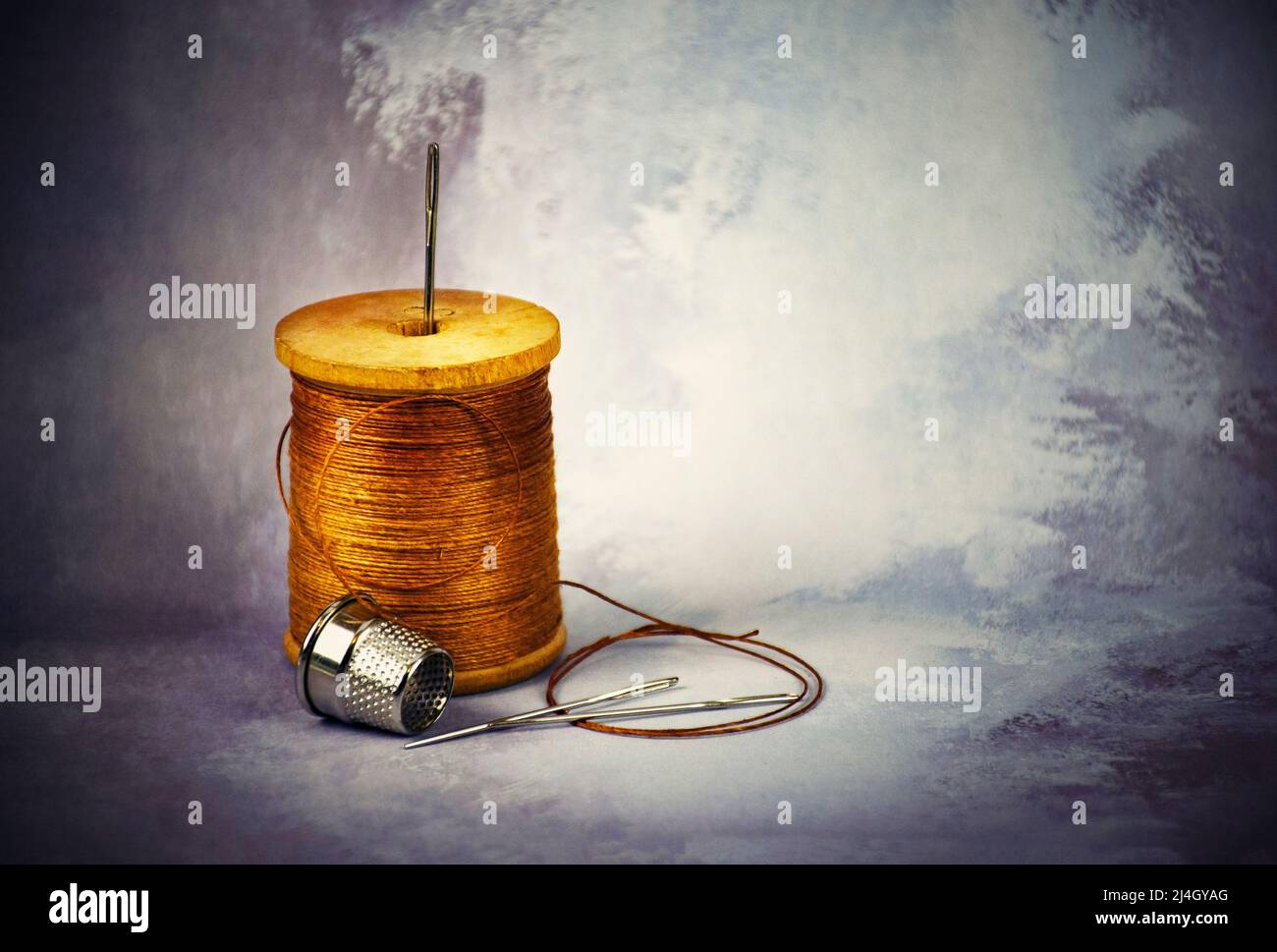 retro background need to sew a needle with thread Stock Photo - Alamy