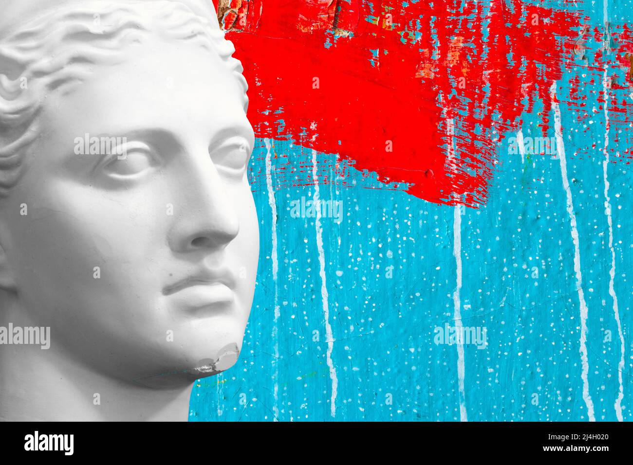 white plaster statue against a wall with red and blue paint. High ...