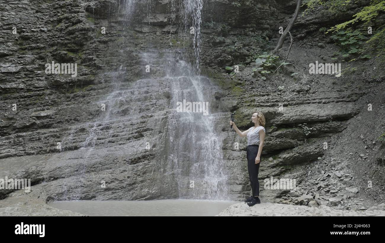 Shooting a waterfall using a camera device. Action. Beautiful nature ...