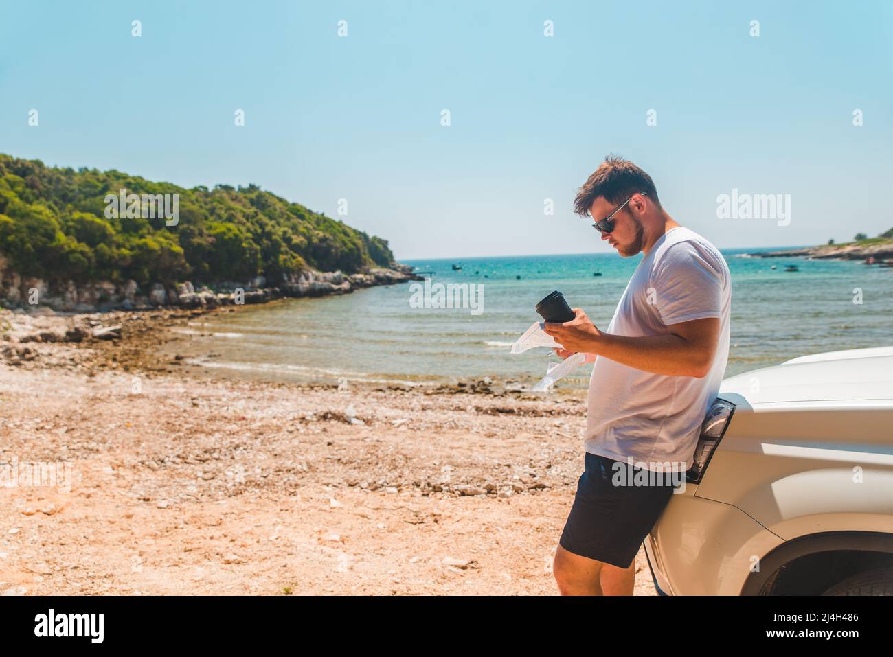 man checking on map at car hood destination place sea beach on ...