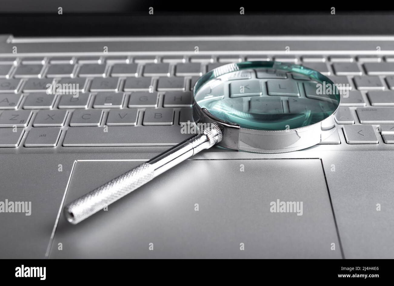 Magnifying glass on laptop keyboard. Internet surfing concept. Online ...