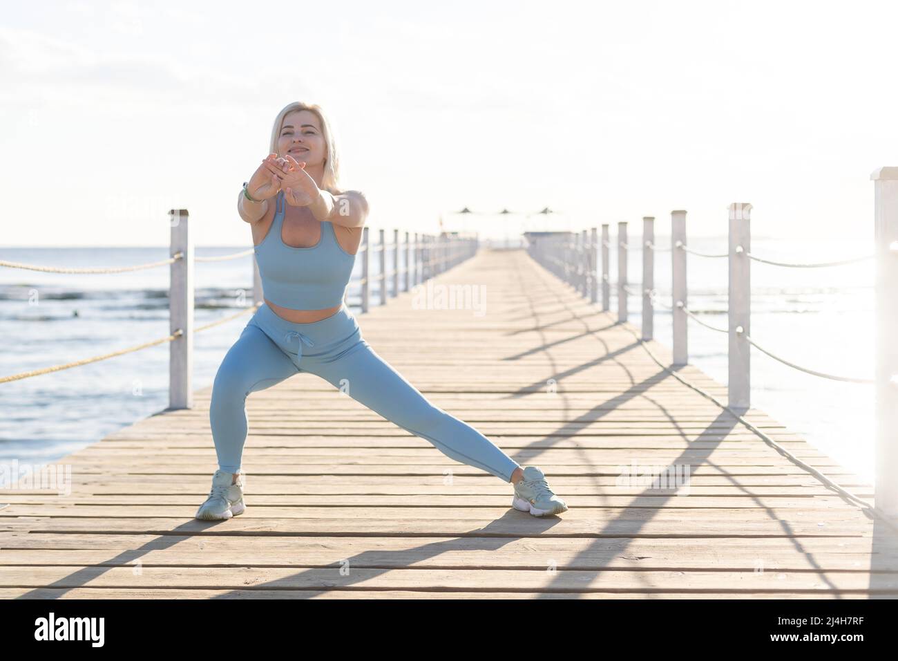 Young fitness woman enjoying warm sunny day in yard of resort hotel ...