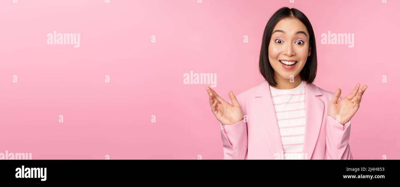 Portrait of asian businesswoman looking surprised at camera, clapping ...