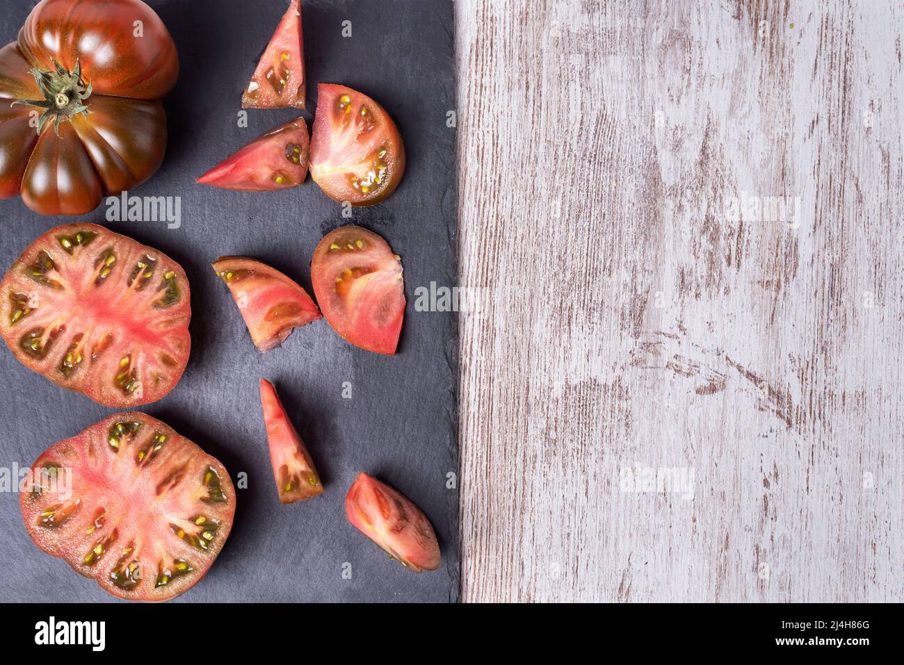 Raf tomato of the black variety, one chopped and the other open in two ...