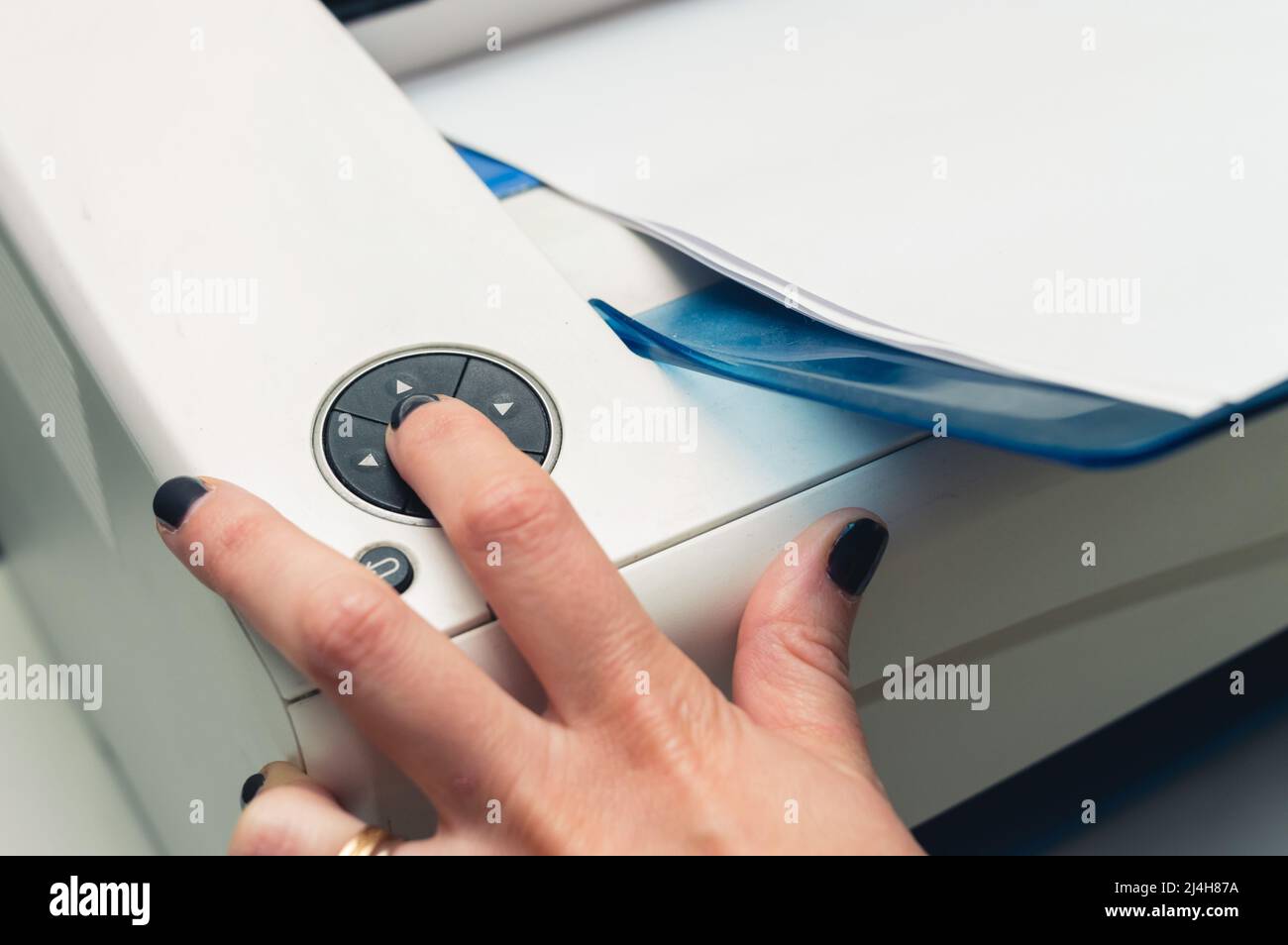 closeup caucasian female hand punching a button in the printer, copy ...