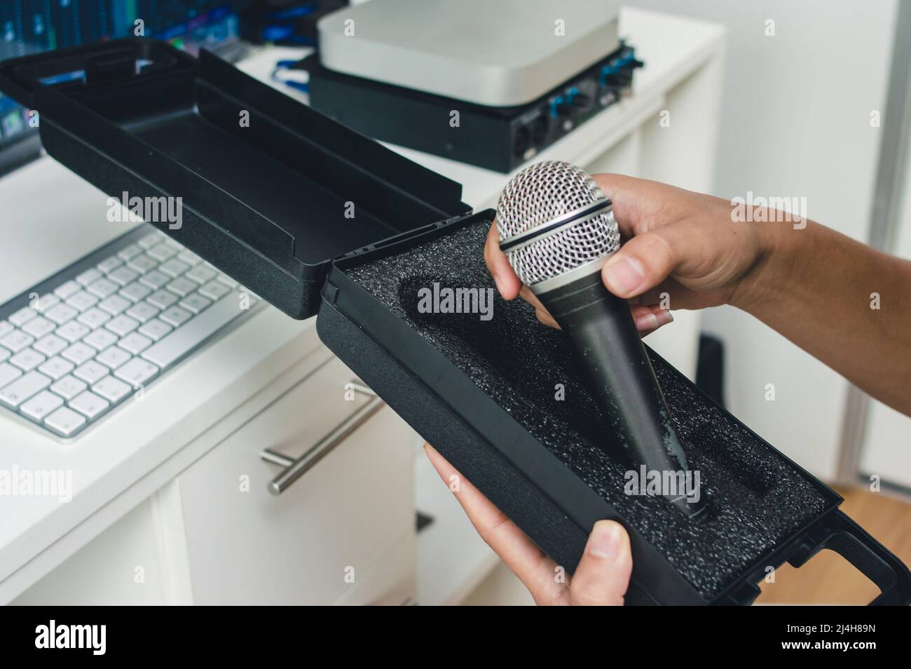 Caucasian male hands in a home music studio taking out a dynamic ...