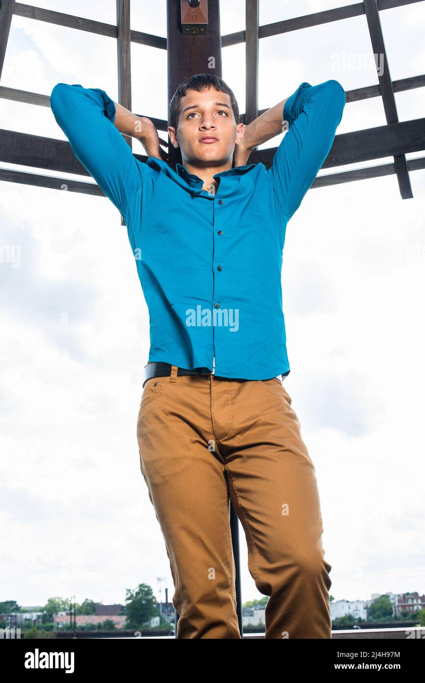 A young attractive guy is raising his arm and pointing to sky ...