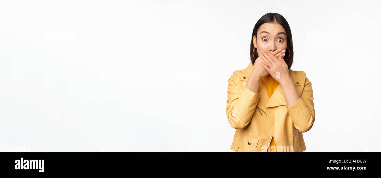 Image of shocked asian girl shuts mouth, close lips and looking ...