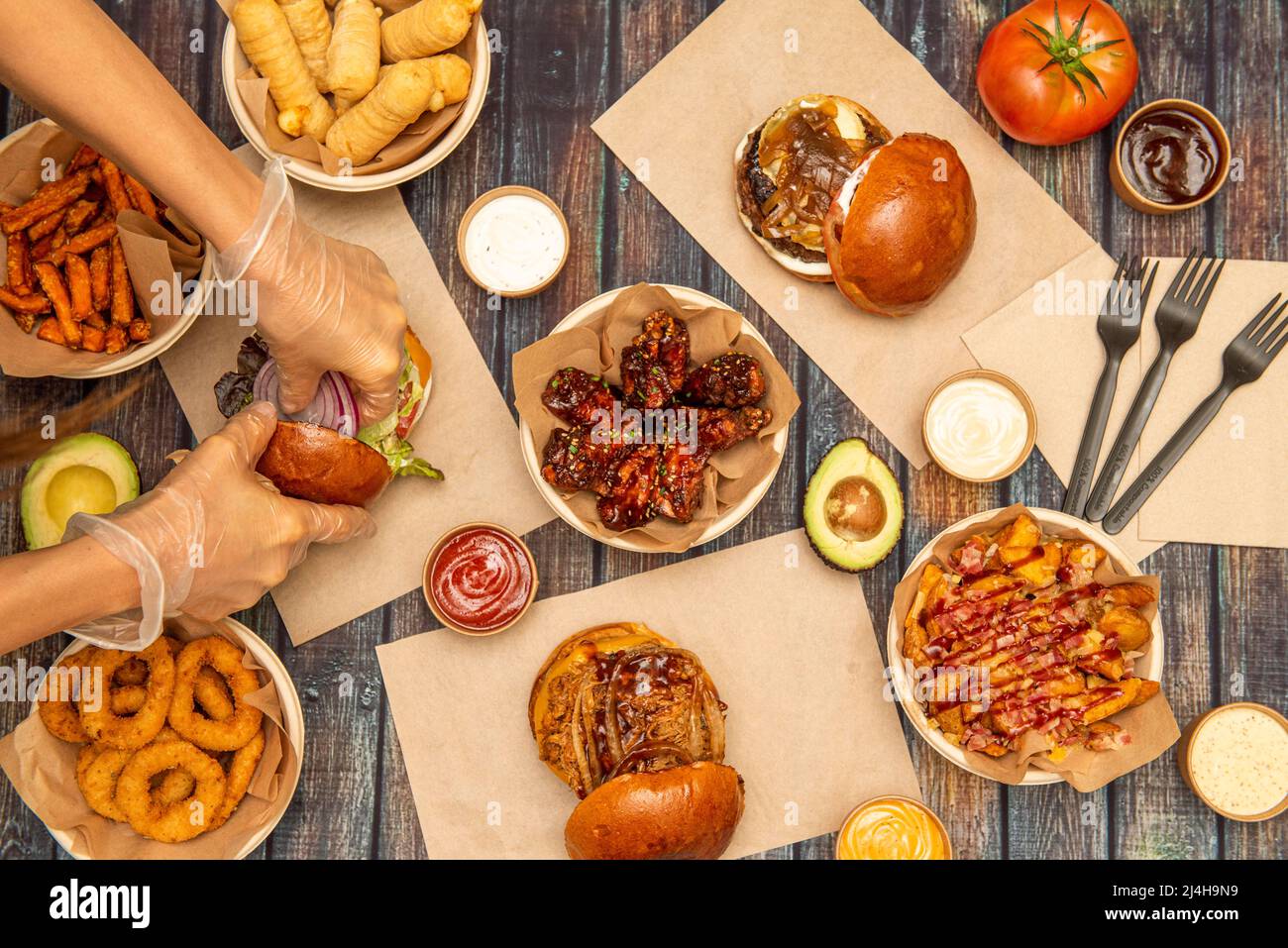 Chef's hands preparing fast food dishes, tequeños, assorted hamburgers ...