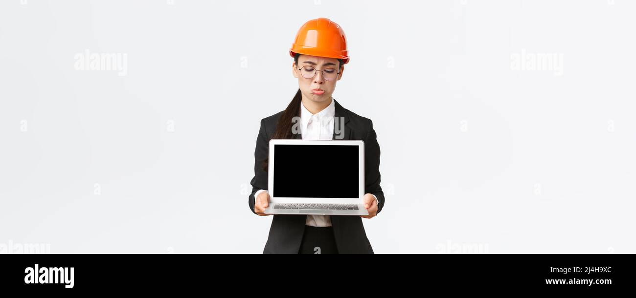 Disappointed gloomy asian female engineer showing bad results, wearing ...