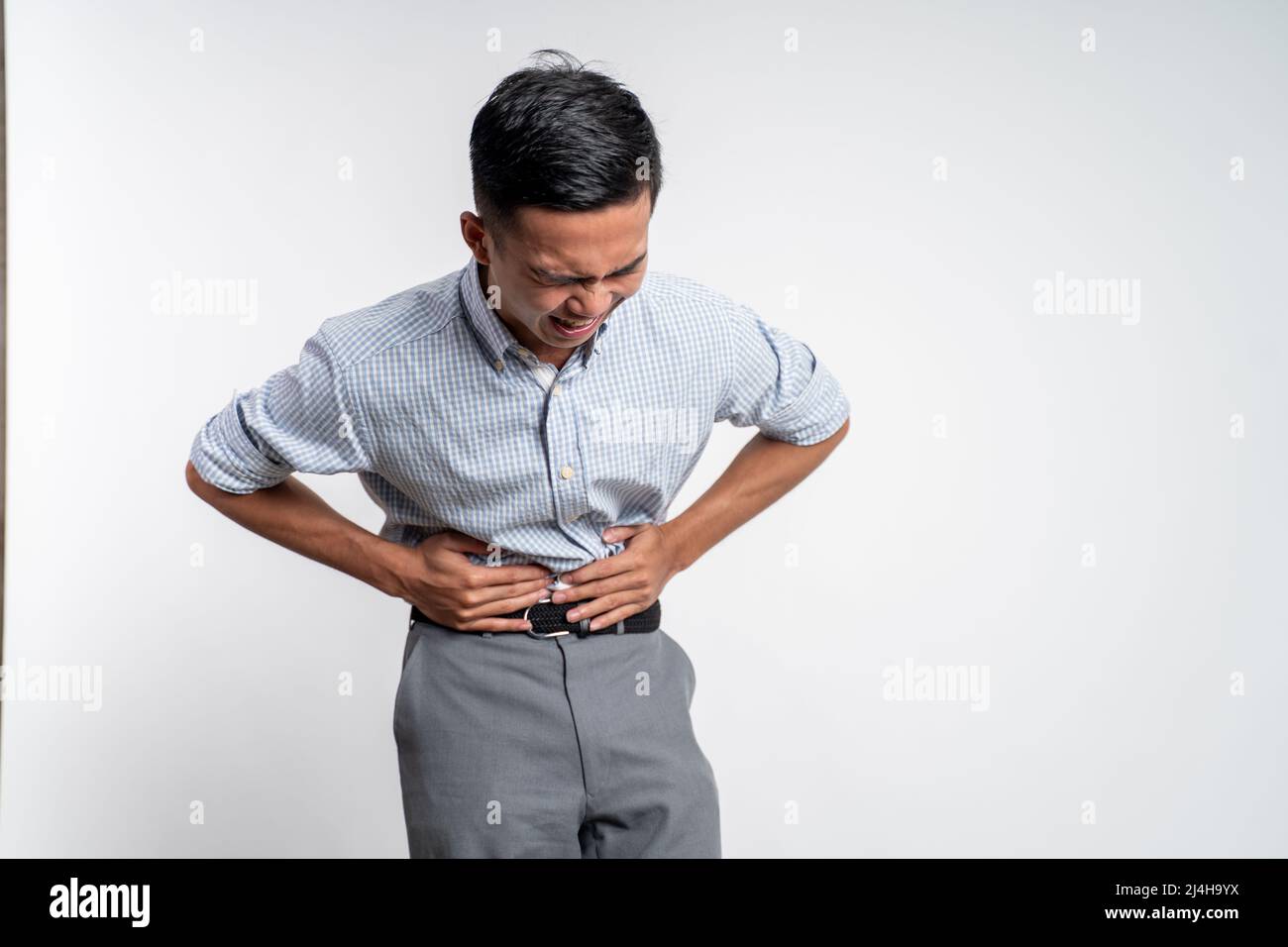 man having stomachache holding his stomach with two hands Stock Photo ...