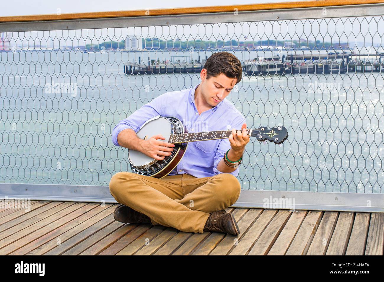 Lowering his head, crossing legs and thinking, a young musician is ...