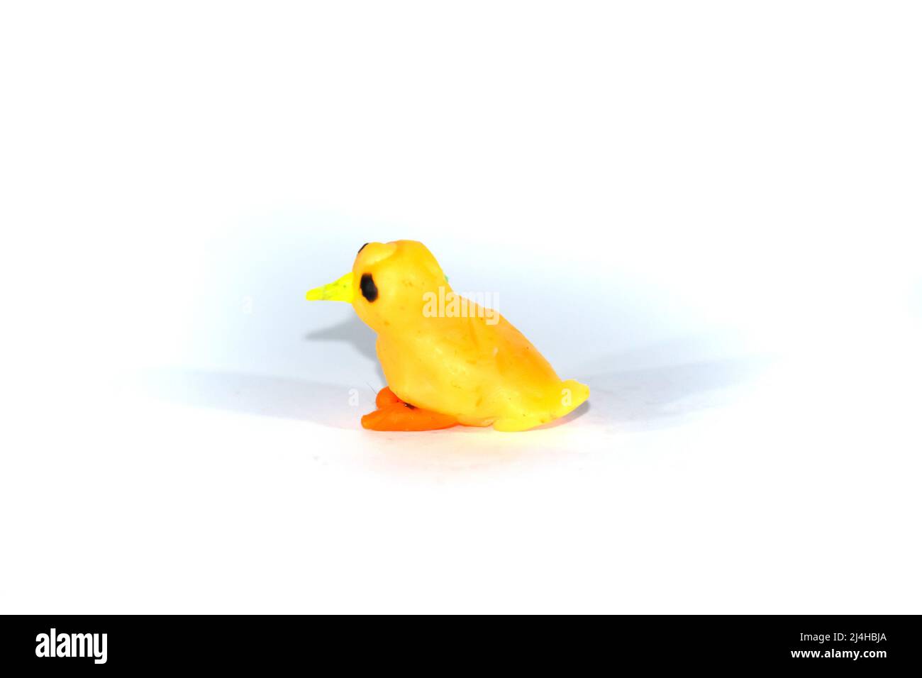 A small yellow chick. Plasticine bird on a white background Stock Photo ...