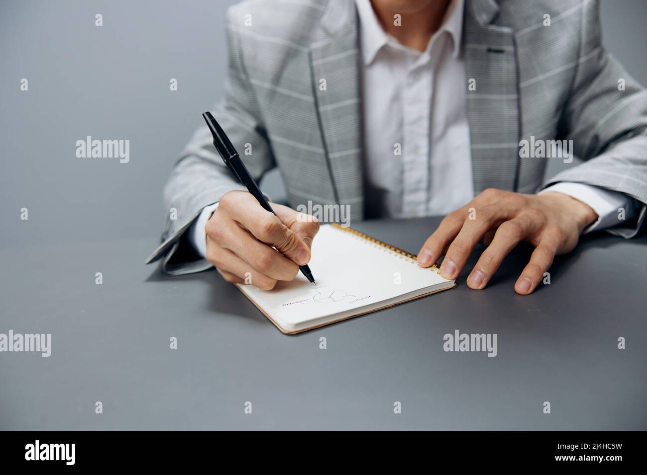 manager in a gray suit in the office with a notepad on the table the ...
