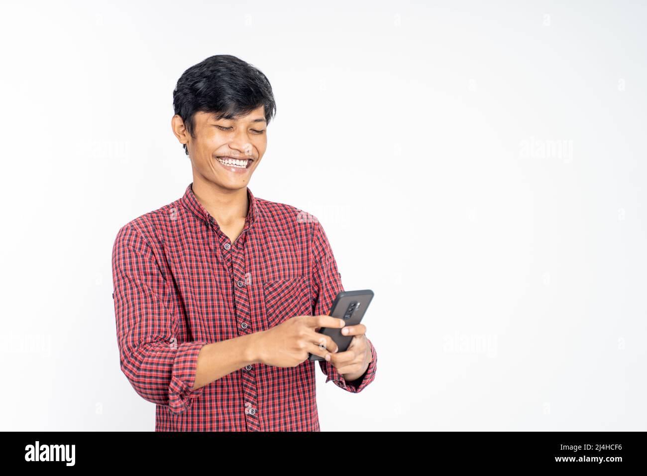 happy asian young man looking at the screen of a mobile phone Stock ...