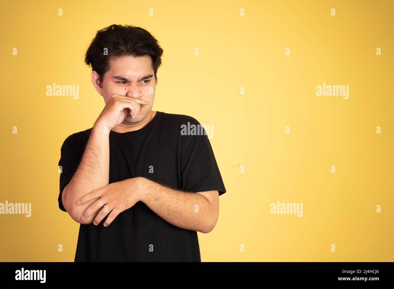 angry asian young man covering nose with hands Stock Photo - Alamy