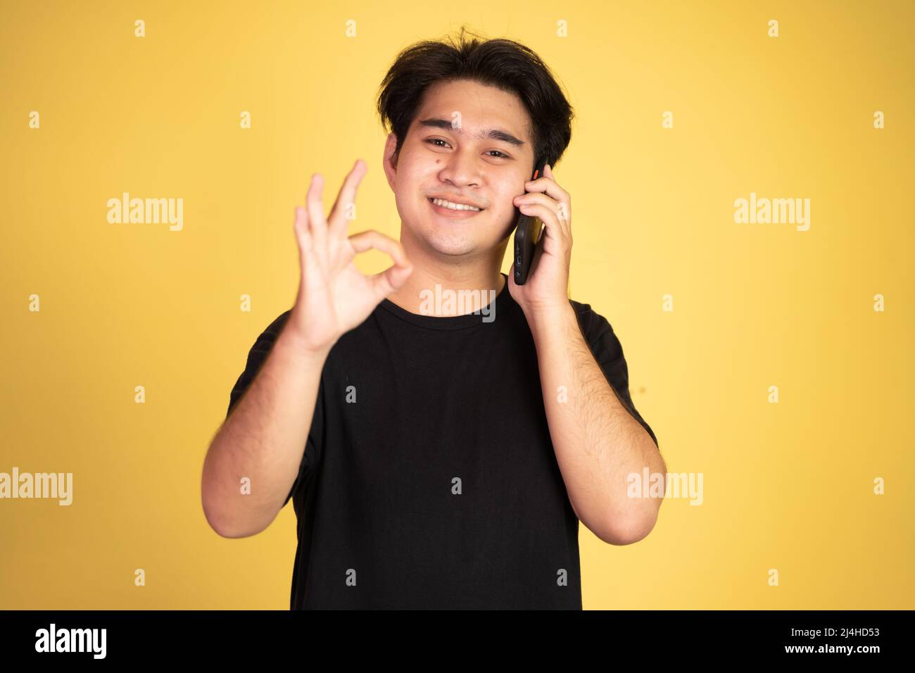 man showing okay gesture while making phone call Stock Photo - Alamy