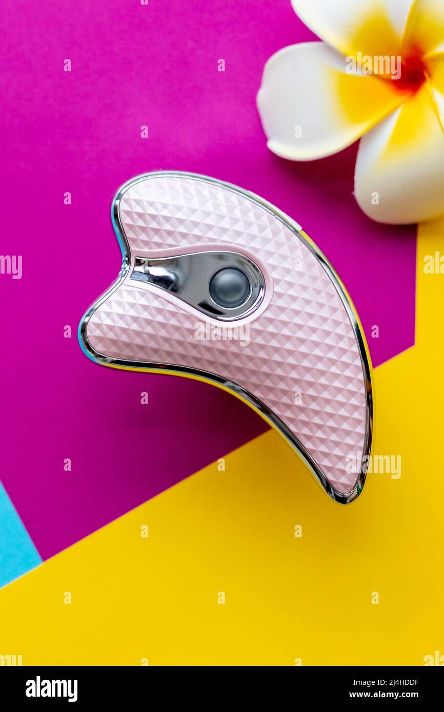 beauty serum and microcurrent toning device on color background with ...