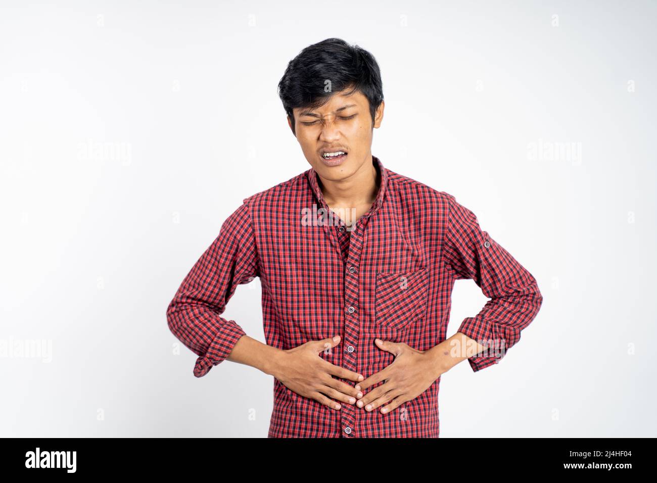 man having stomachache holding his stomach with two hands Stock Photo ...