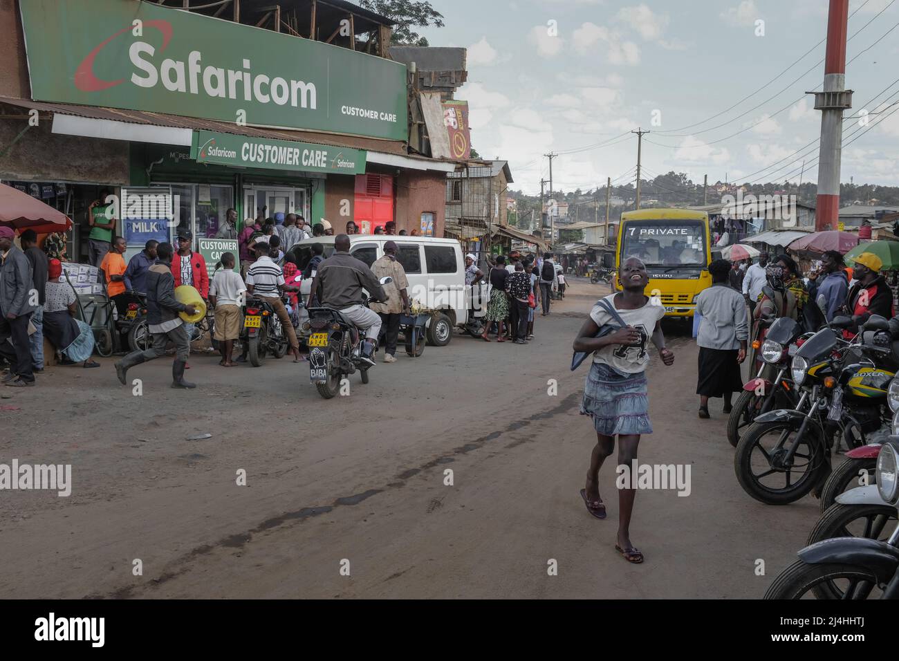A girl runs through the busy street in Kibera Stock Photo - Alamy
