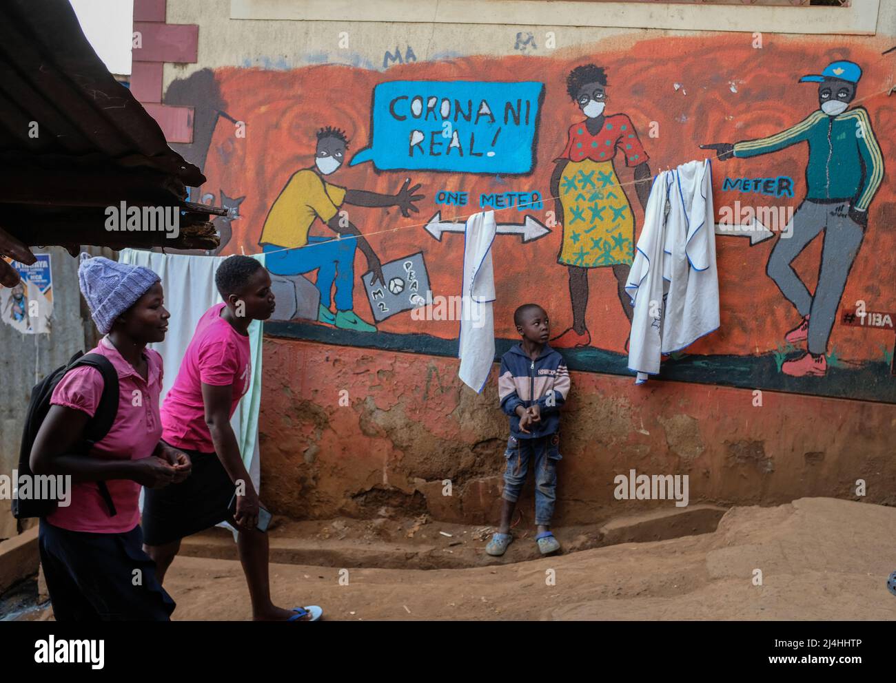 A boy poses by a mural promoting awareness of the coronavirus disease ...