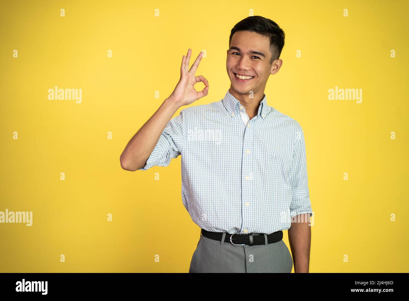 asian young man showing okay hand gesture with smiling Stock Photo - Alamy